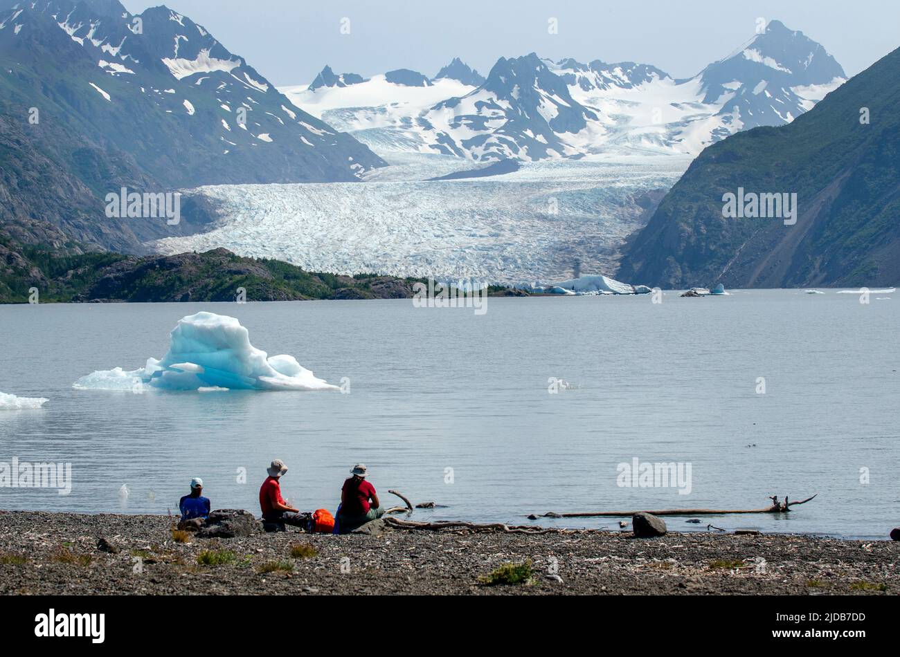 Hikers take a break to watch icebergs push against the shore of the ...