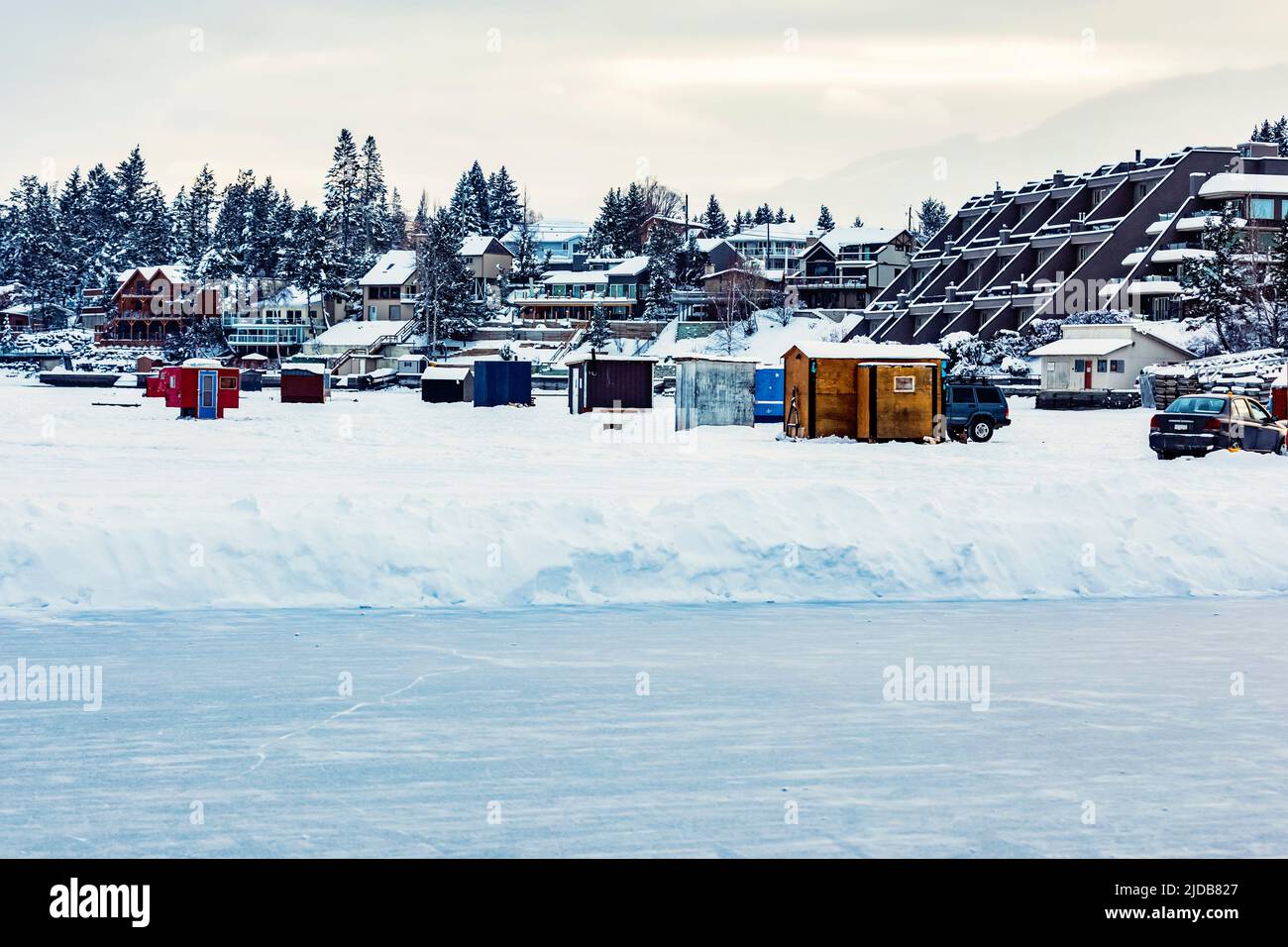 A view of a skating rink and ice fishing shacks and trailers on the ...