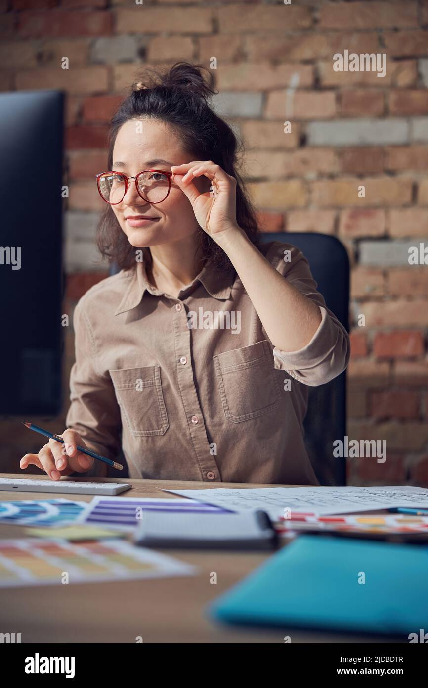 Concentrated female interior architect or designer working on a project ...