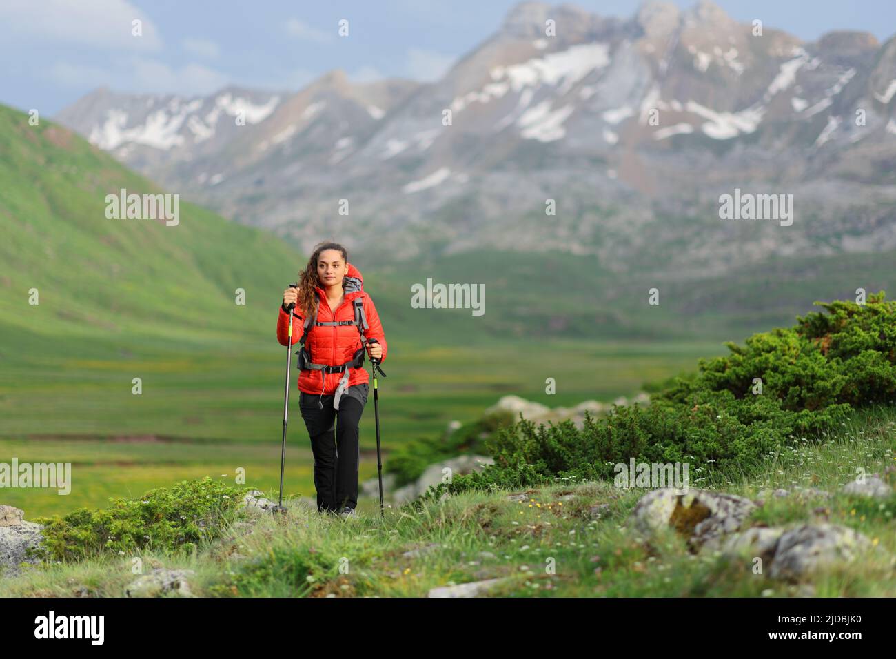 Front view portrait of a hiker walking in a green high mountain Stock ...