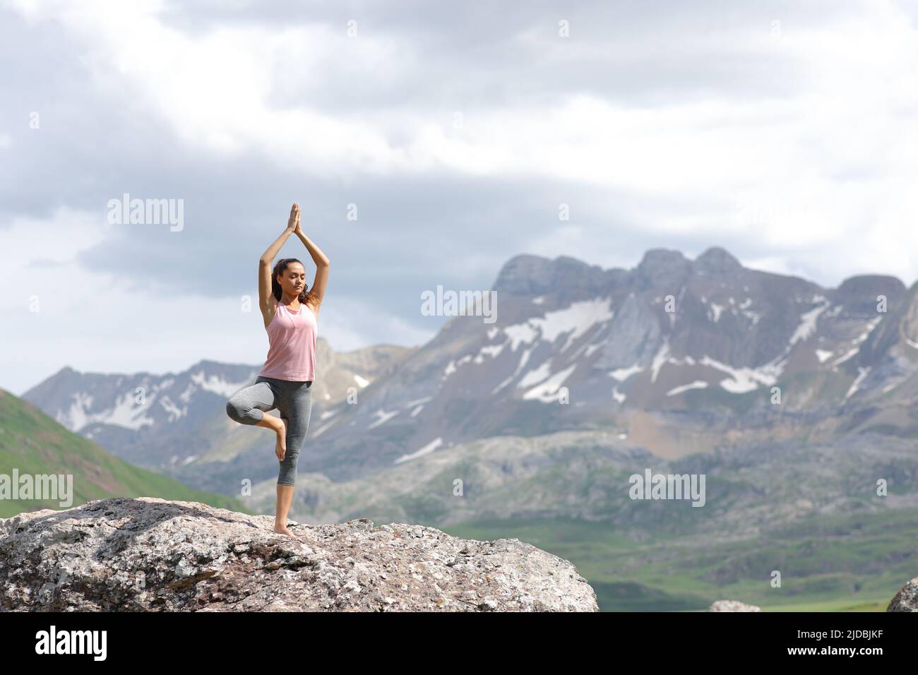 Full body portrait of a yogi practicing yoga exercise in the top of a ...