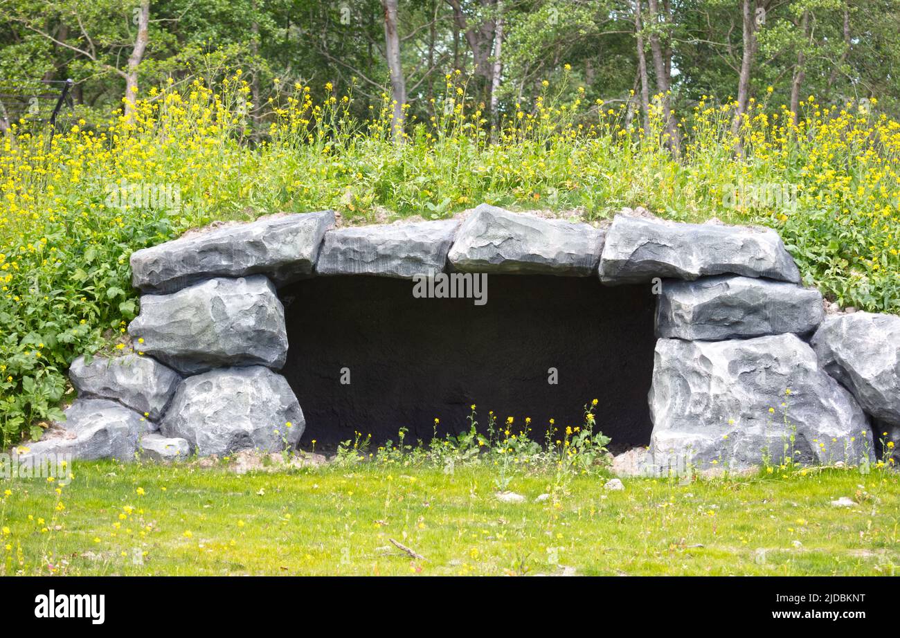 Empty man made cave, overgrown with grass Stock Photo - Alamy