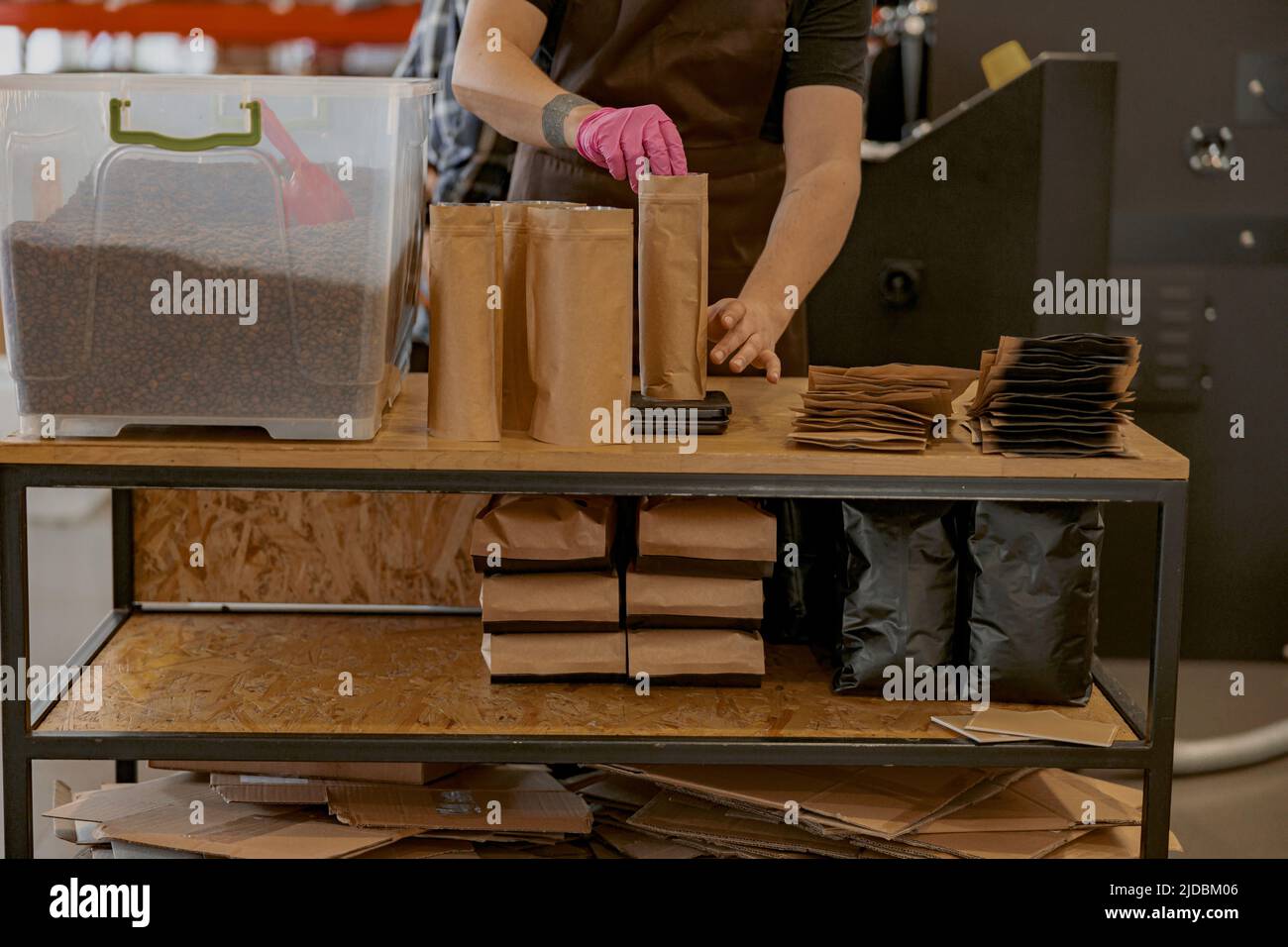 Close up of male hands weighs paper bag with coffee beans on a scale at ...