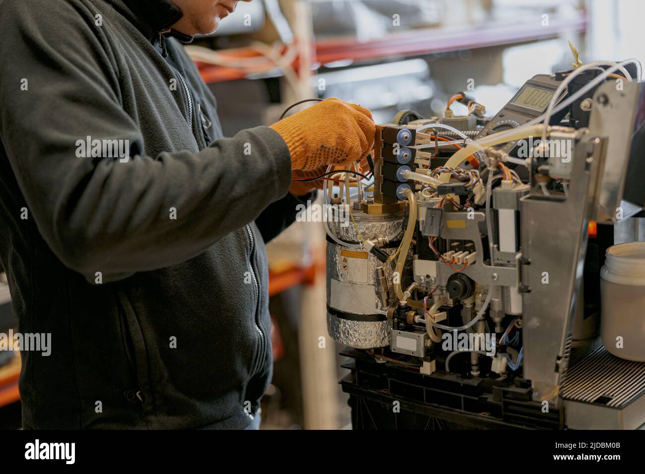 Professional worker fixing coffee machine in workshop Stock Photo - Alamy