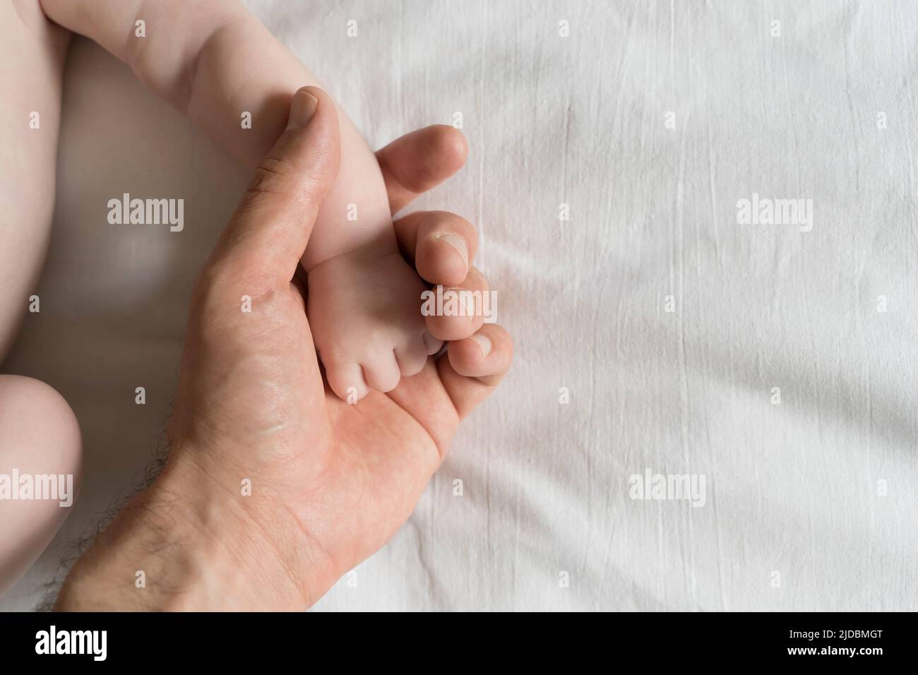 Baby's hand in the palm of his father on a white background. Care ...