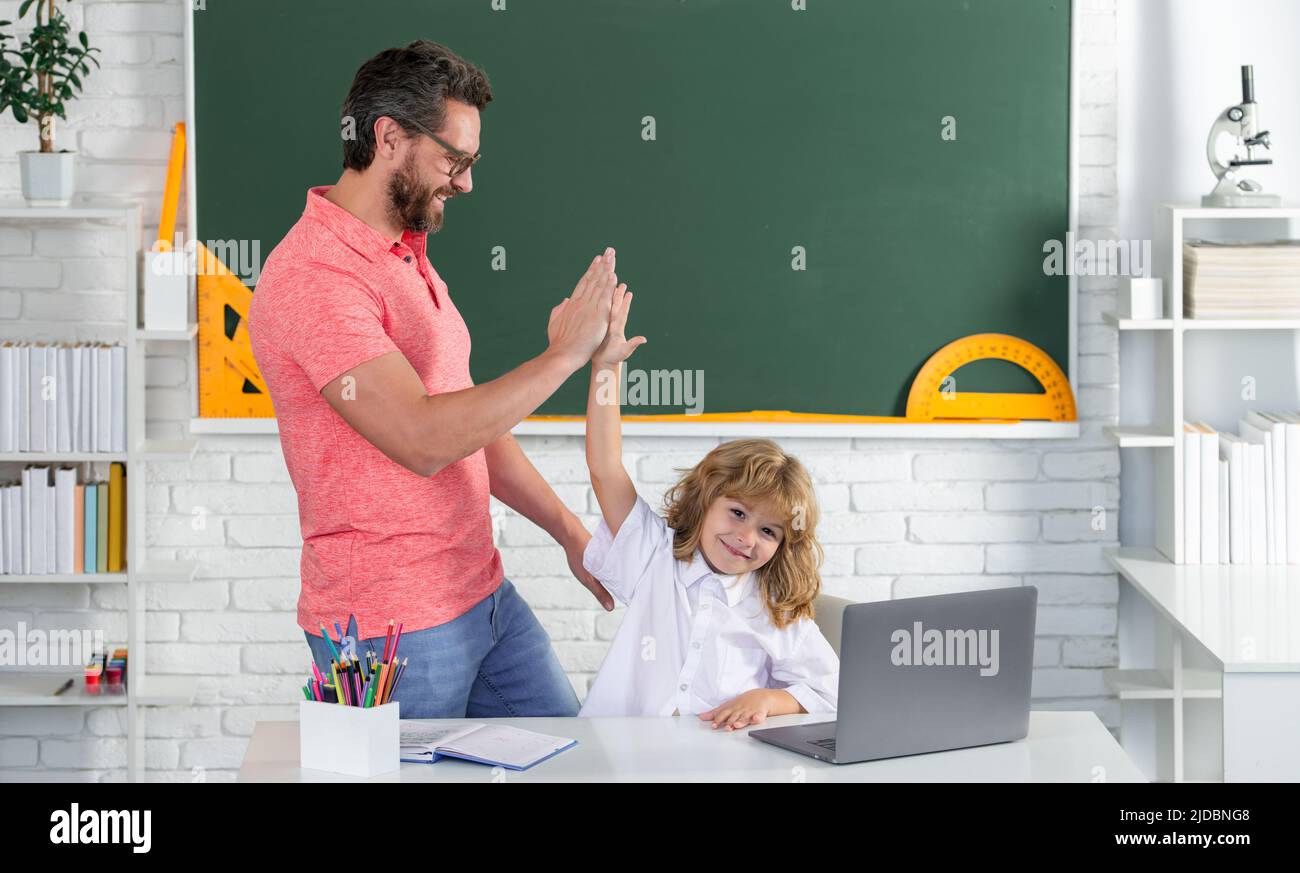 School kid and teacher learning study in class. Teacher helping child ...