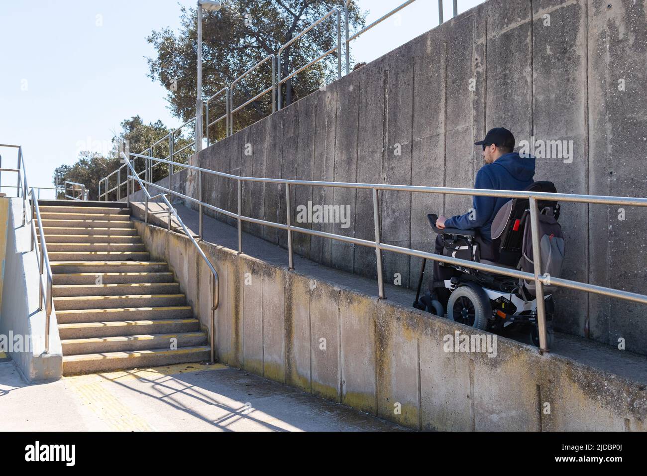 Man on a wheelchair use accessible ramp Stock Photo - Alamy