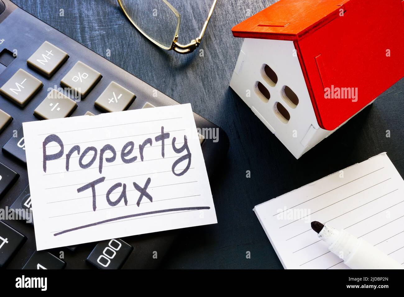 Property tax reminder on calculator and house model Stock Photo - Alamy