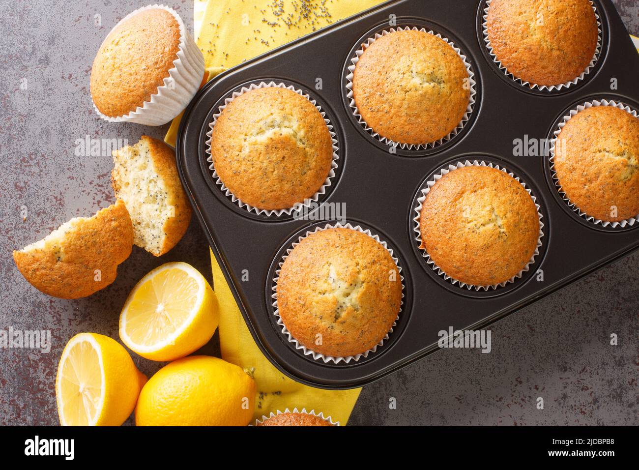 Homemade tender muffins with poppy seeds and lemon close-up in a metal ...