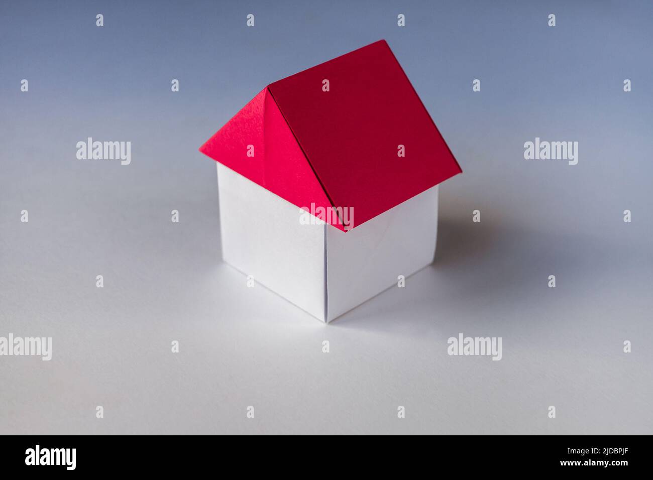 White and red paper house origami isolated on a blank background Stock ...