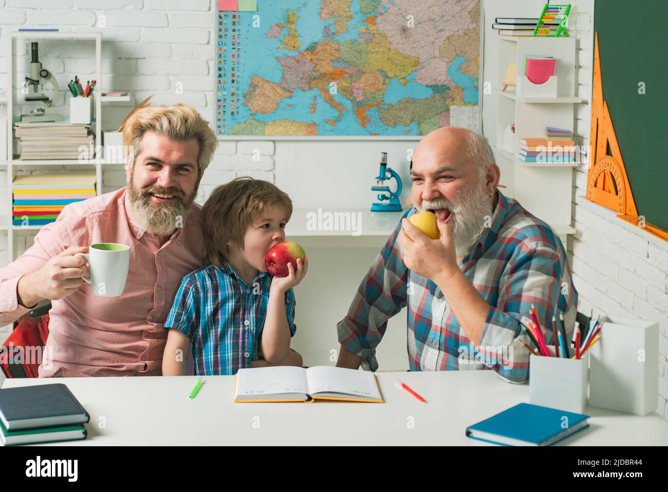 Fathers day. Happy smiling grandson boy with dad and granddad learning ...