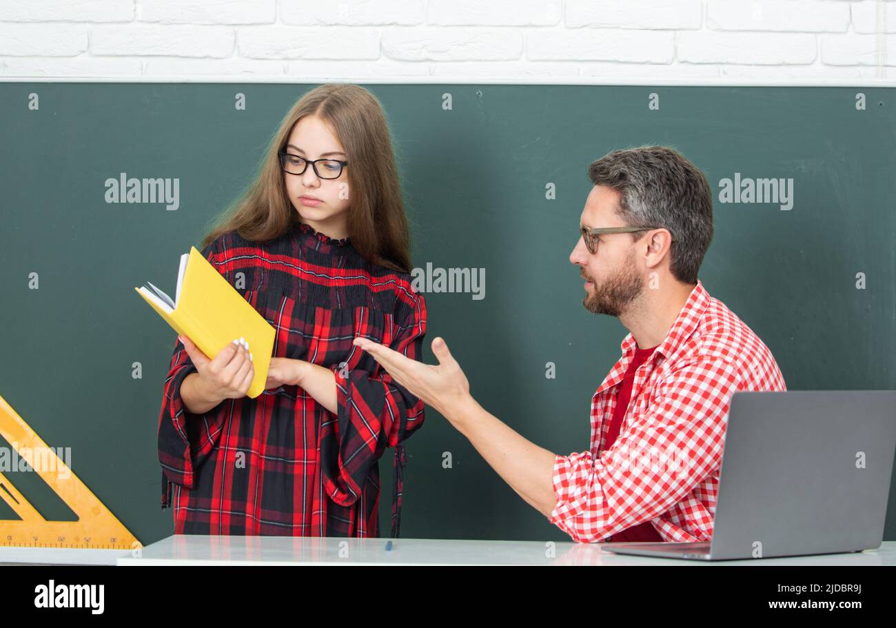 Teacher explains lesson to school child. Elementary school kids ...
