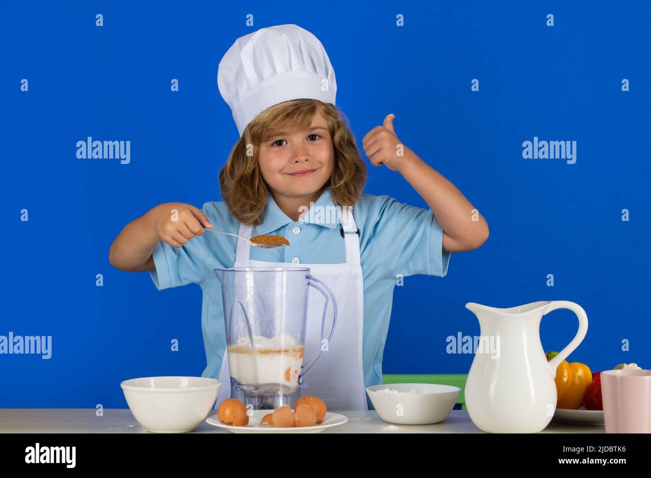 Child chef isolated on blue. Funny little kid chef cook wearing uniform ...