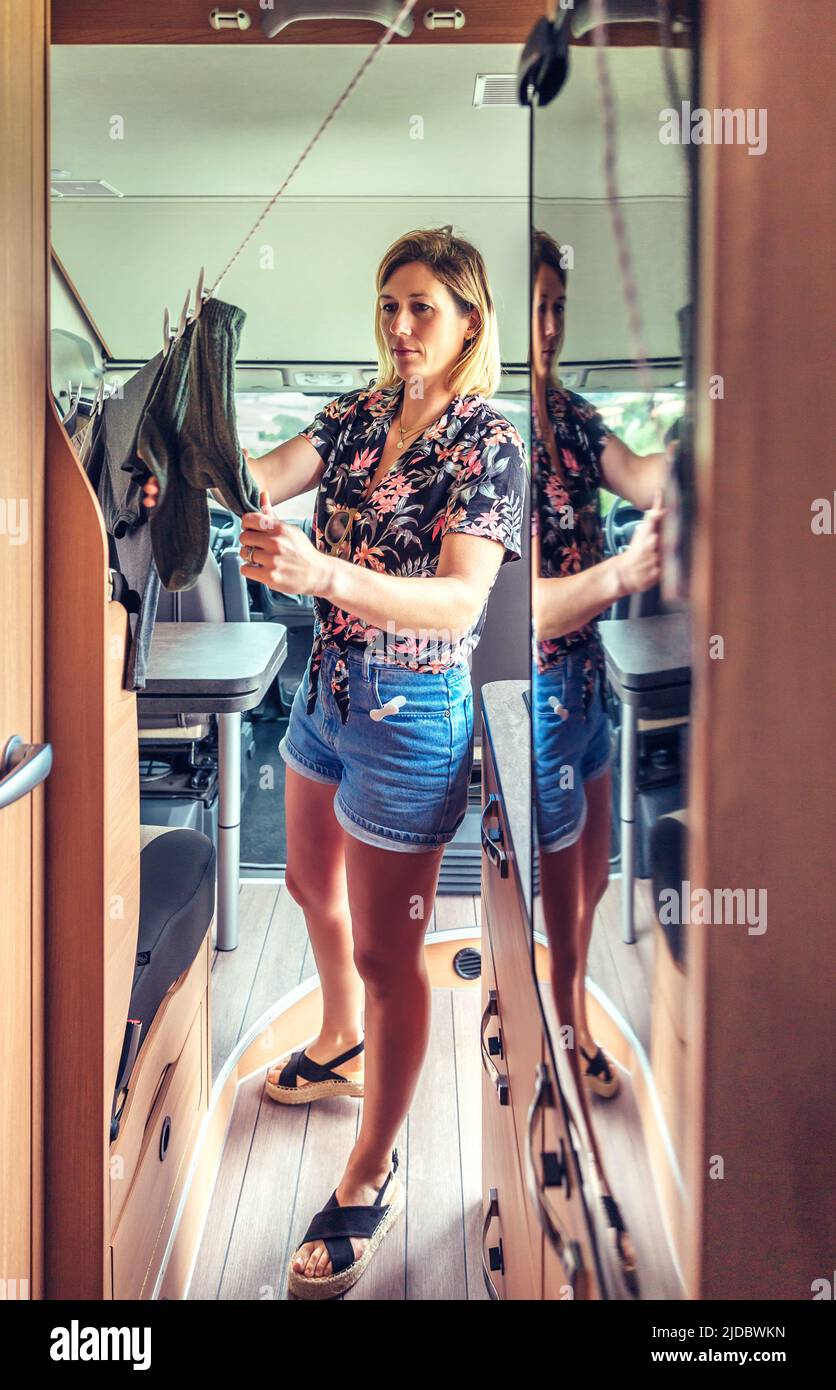 Woman hanging clothes on a clothesline inside her camper van Stock ...