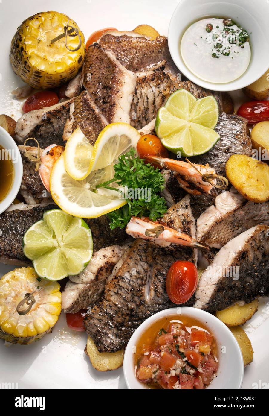 mixed fried fish plate with seared seabass and red snapper on white ...
