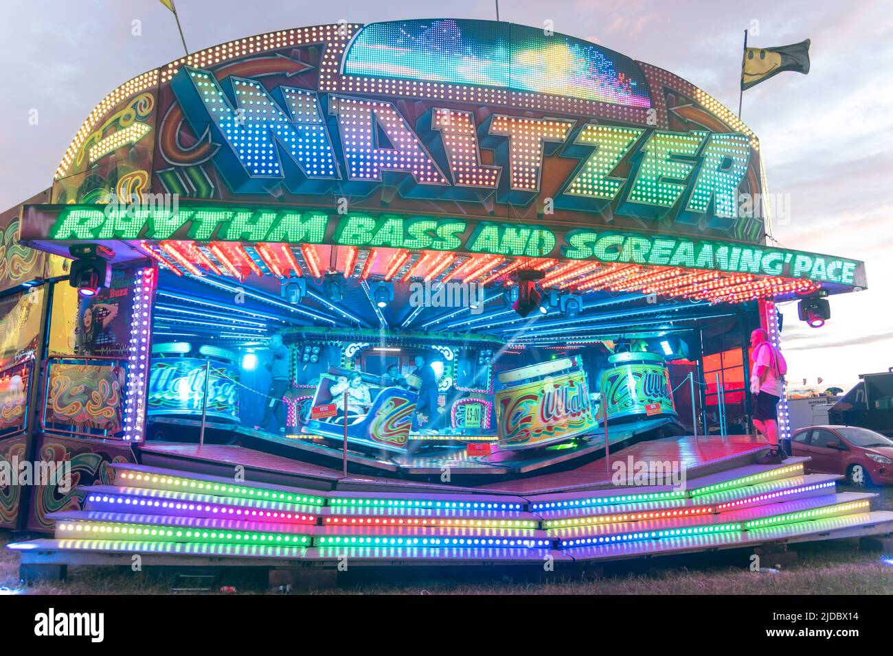 The Waltzer funfair ride in full swing, under an evening sky Stock Photo - Alamy