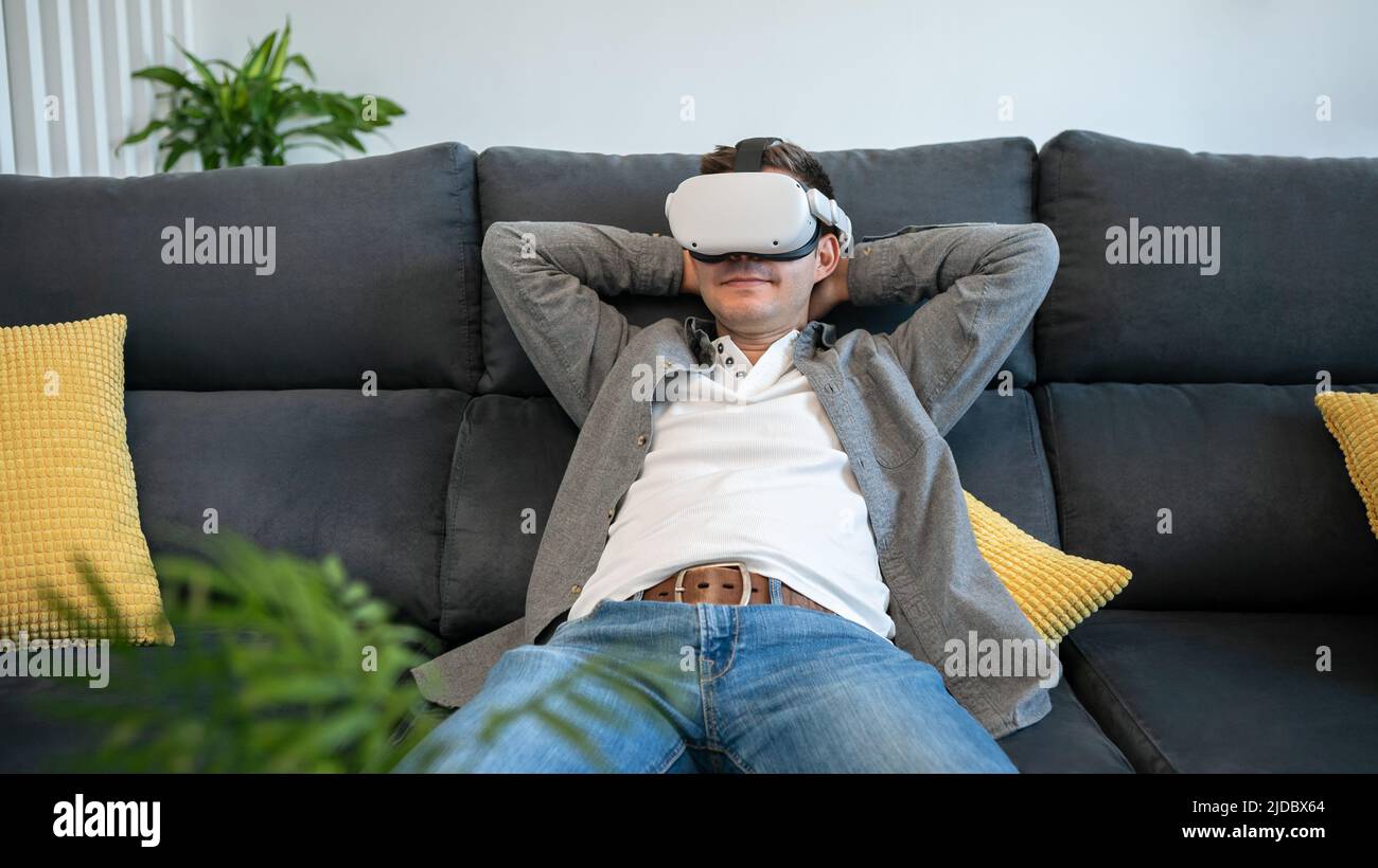 Bearded man watching movie with VR glasses headset sitting on ...