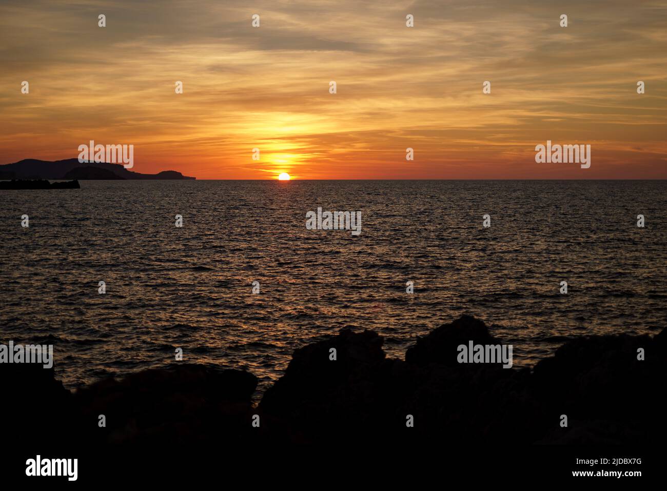 Orange sunset in Menorca Stock Photo - Alamy