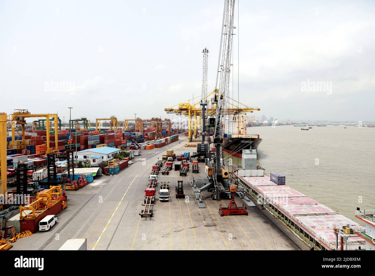 Aerial view of containers and shipyard cranes and trucks are at ...