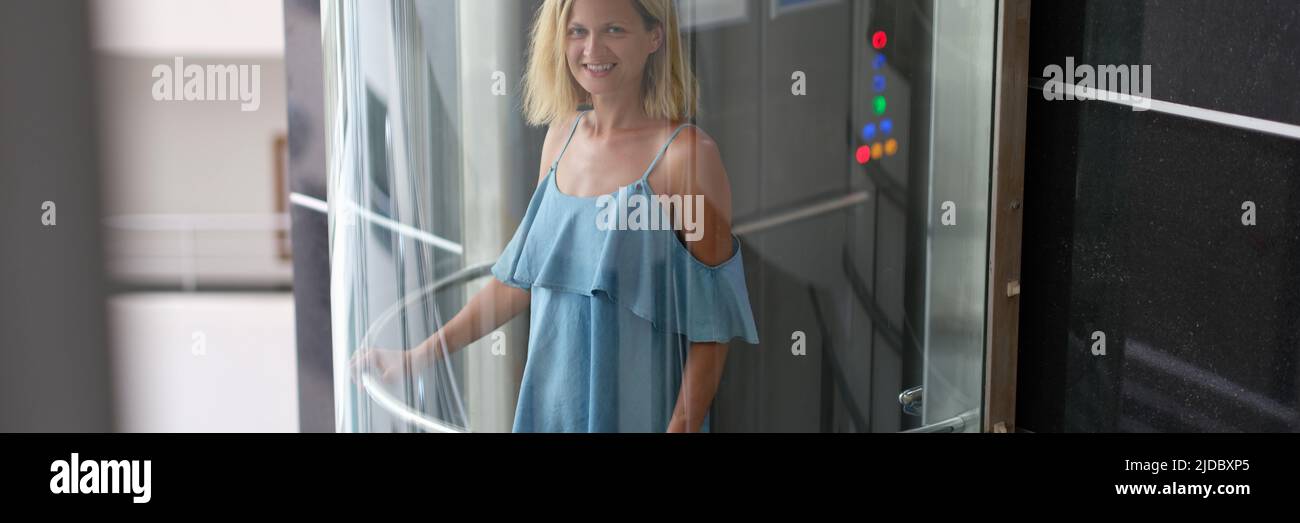 Happy woman in dress rides in a glass elevator Stock Photo - Alamy