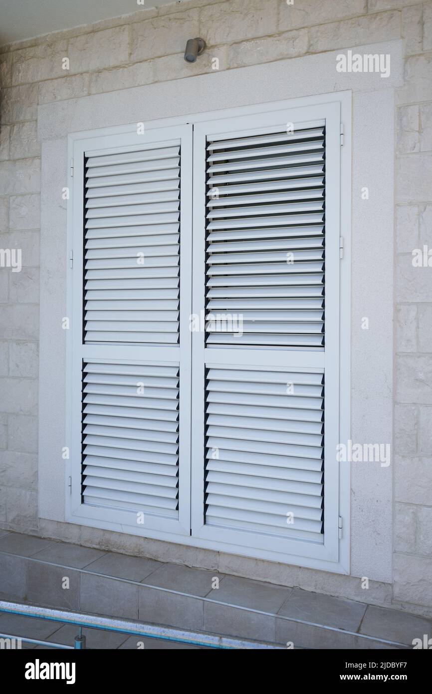 Plastic external window shutters on a residential building Stock Photo - Alamy