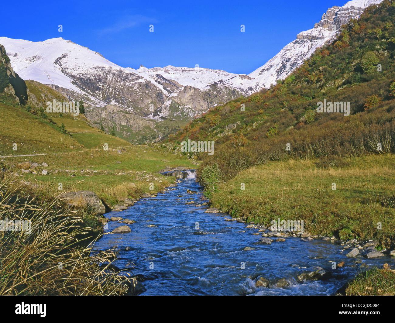 France, Savoie Beaufortain Massif mountain torrent with snowy peaks ...