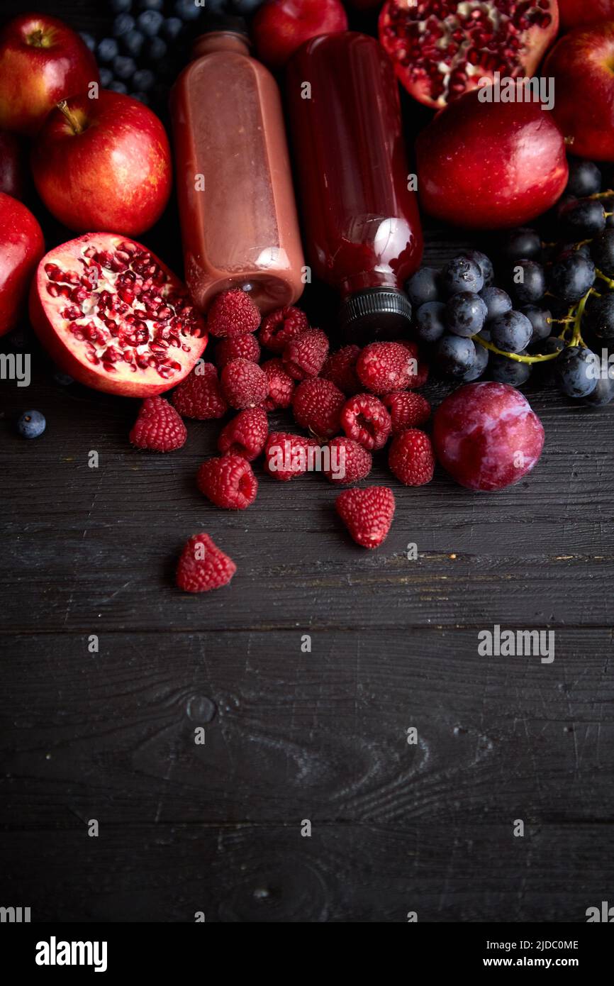Various fresh red, purple black fruits. Mix of fruits and bottled ...