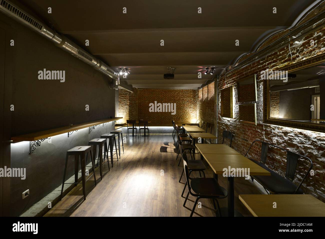 Dining room of a restaurant with mirrors on the walls, wooden tables ...