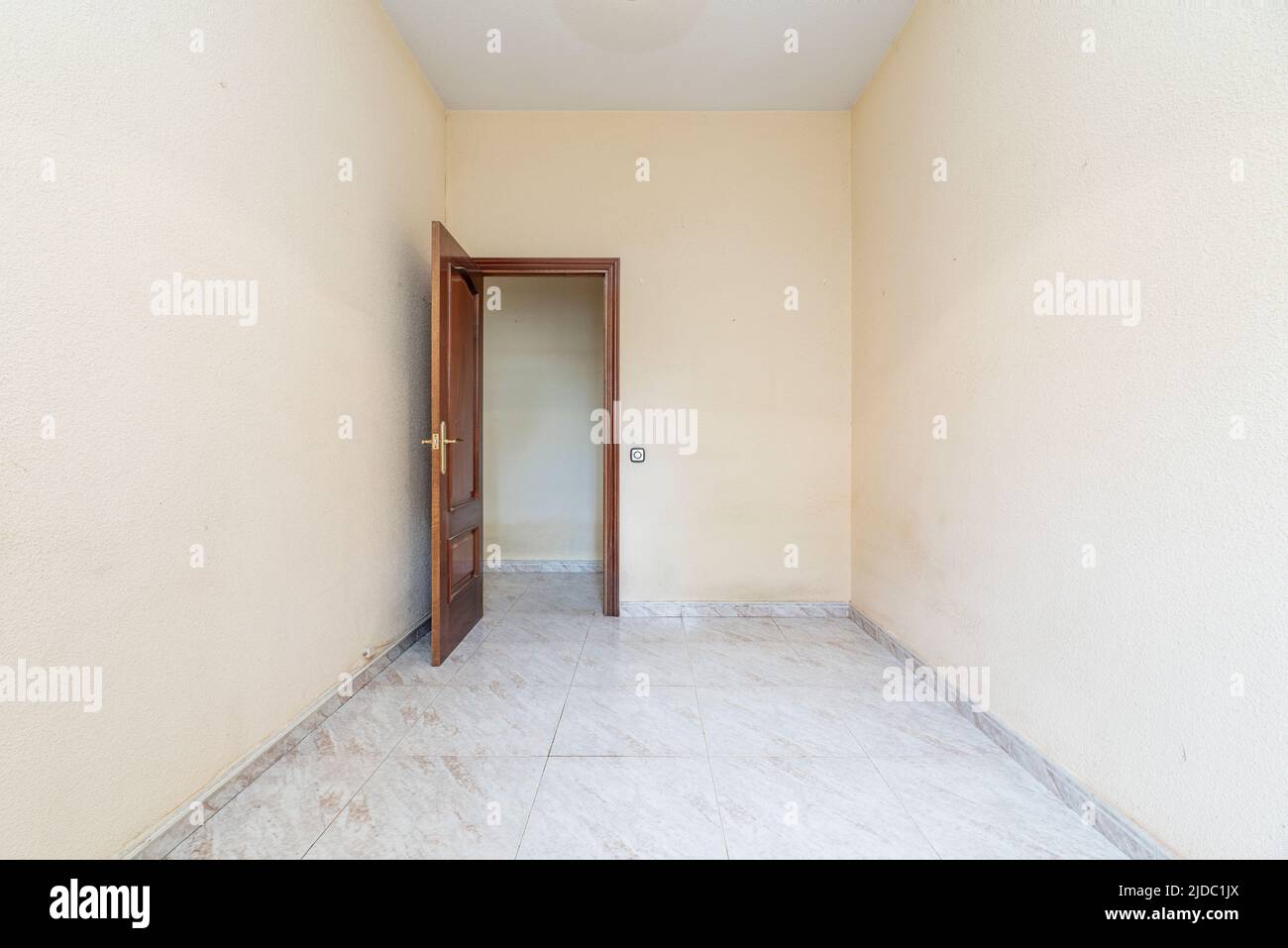 Empty room with light cream painted walls, stoneware floor and a ...