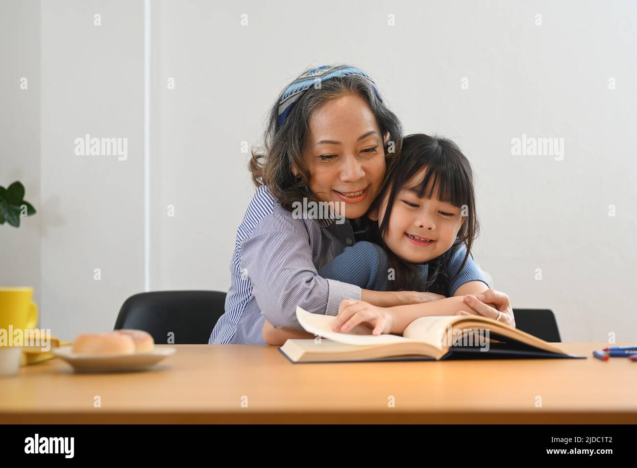 Caring grandma telling story, reading fairy tale to her little ...