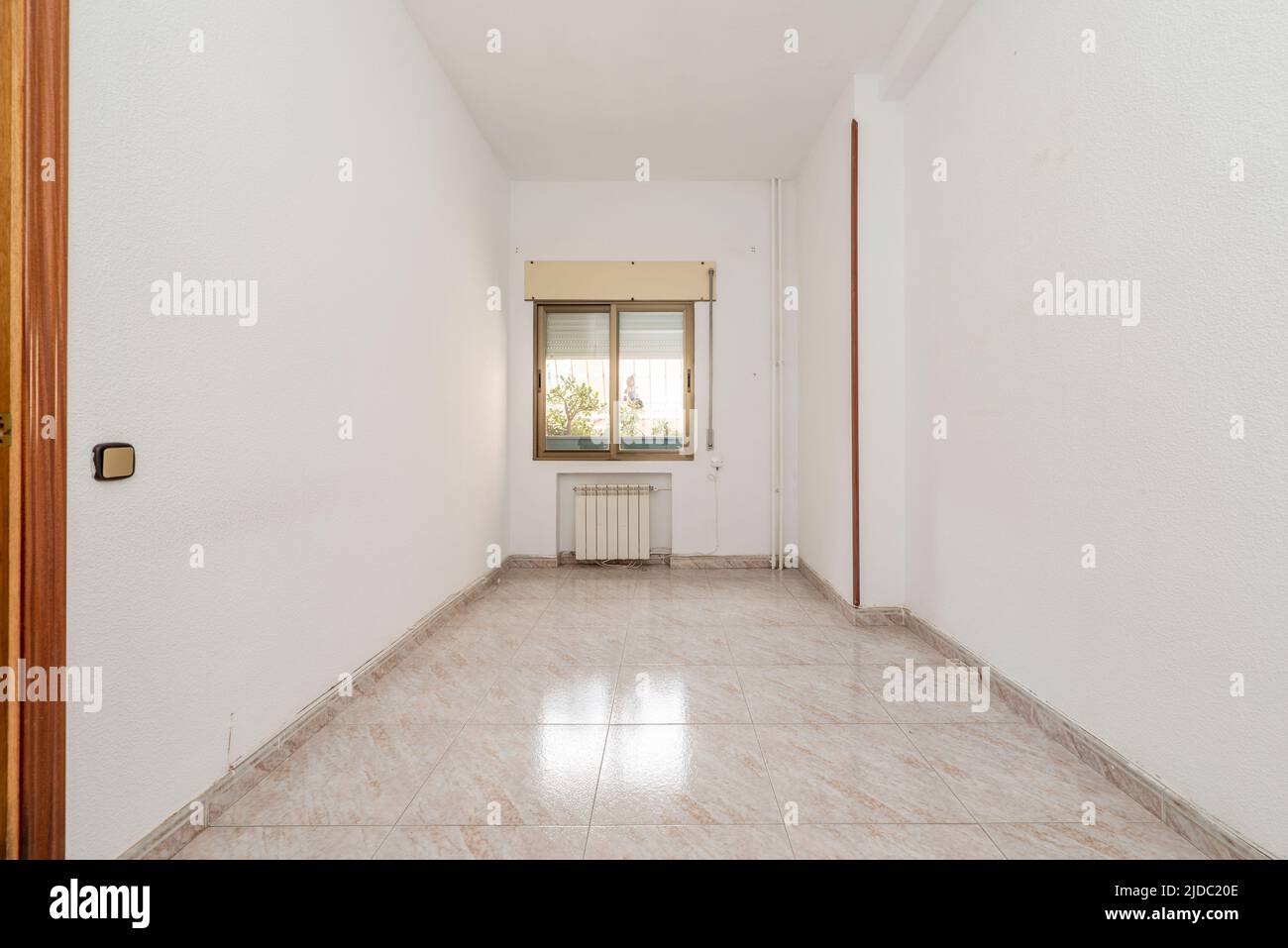 empty room with ceramic tile floors, gold aluminum window and white ...
