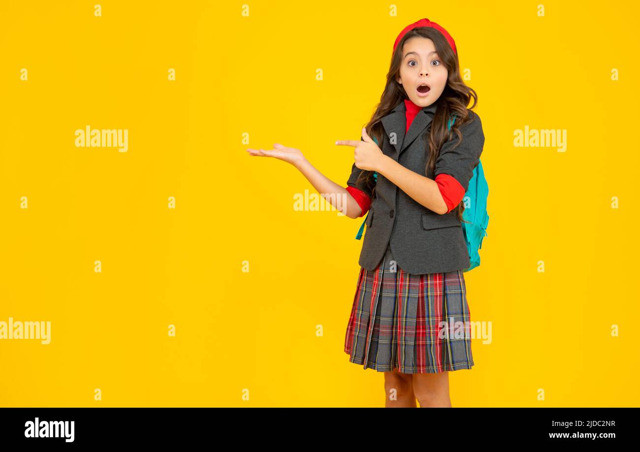 amazed child in school uniform with backpack pointing finger on copy ...