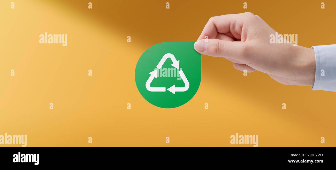Female hand holding a badge with recycling symbol, sustainability and ...