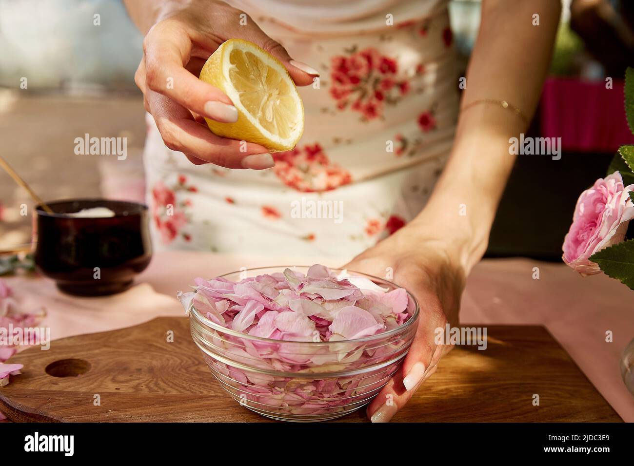 Woman adding drops of lemon to tea roses petals. Aesthetic homemade ...