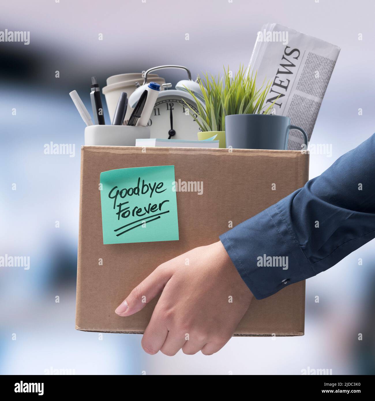 Office Worker Carrying Personal Belongings In A Box After Being Fired