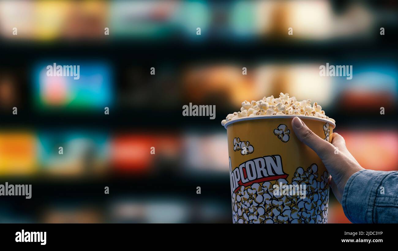 Woman eating popcorn and watching videos on demand at home on TV Stock ...