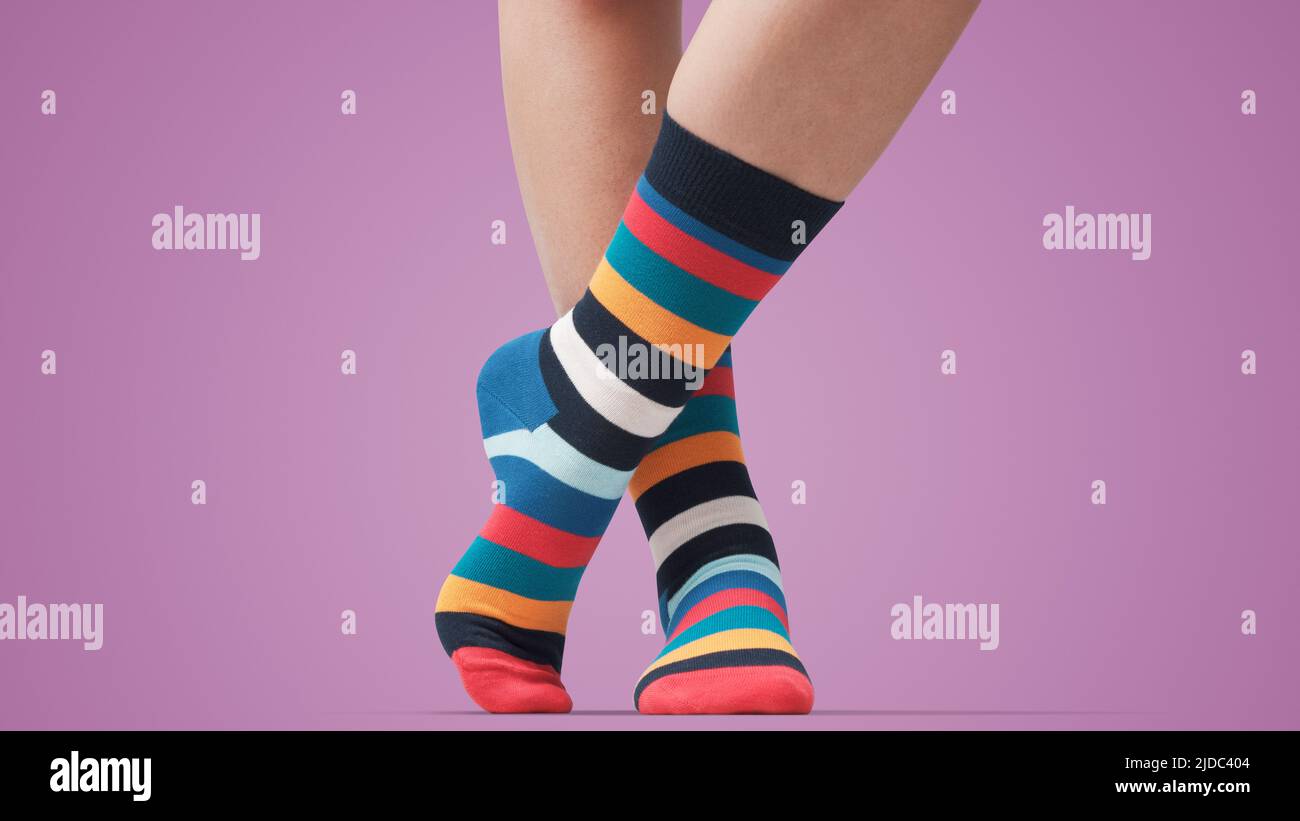 Model posing with colorful striped socks and standing, feet close up ...