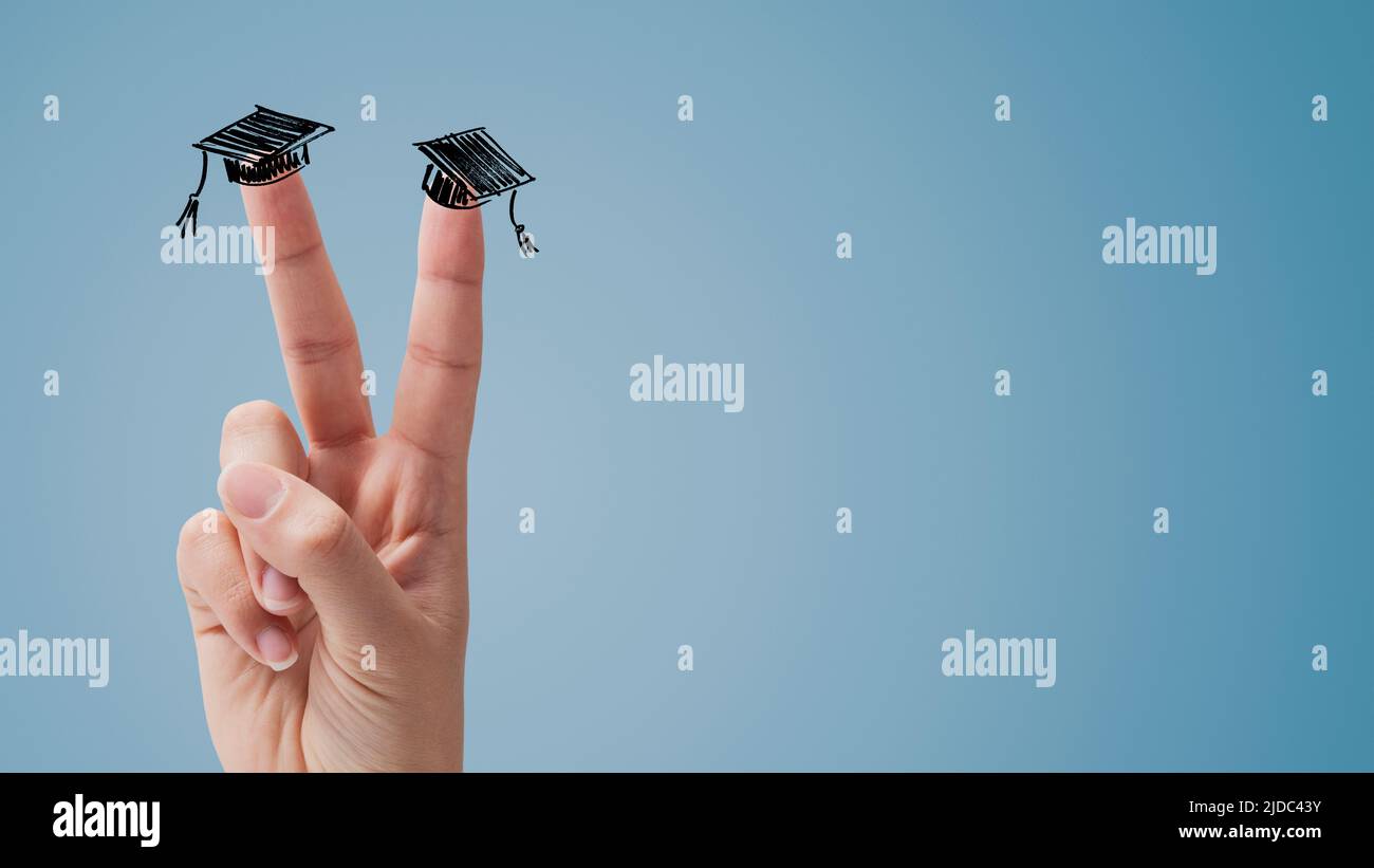 V sign gesture and sketched academic caps on fingers, university and ...