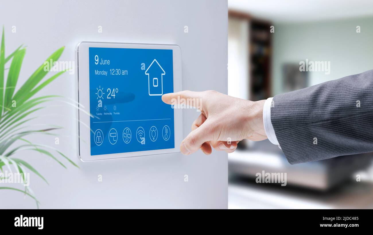 Man checking a smart home touch screen control panel, home automation ...