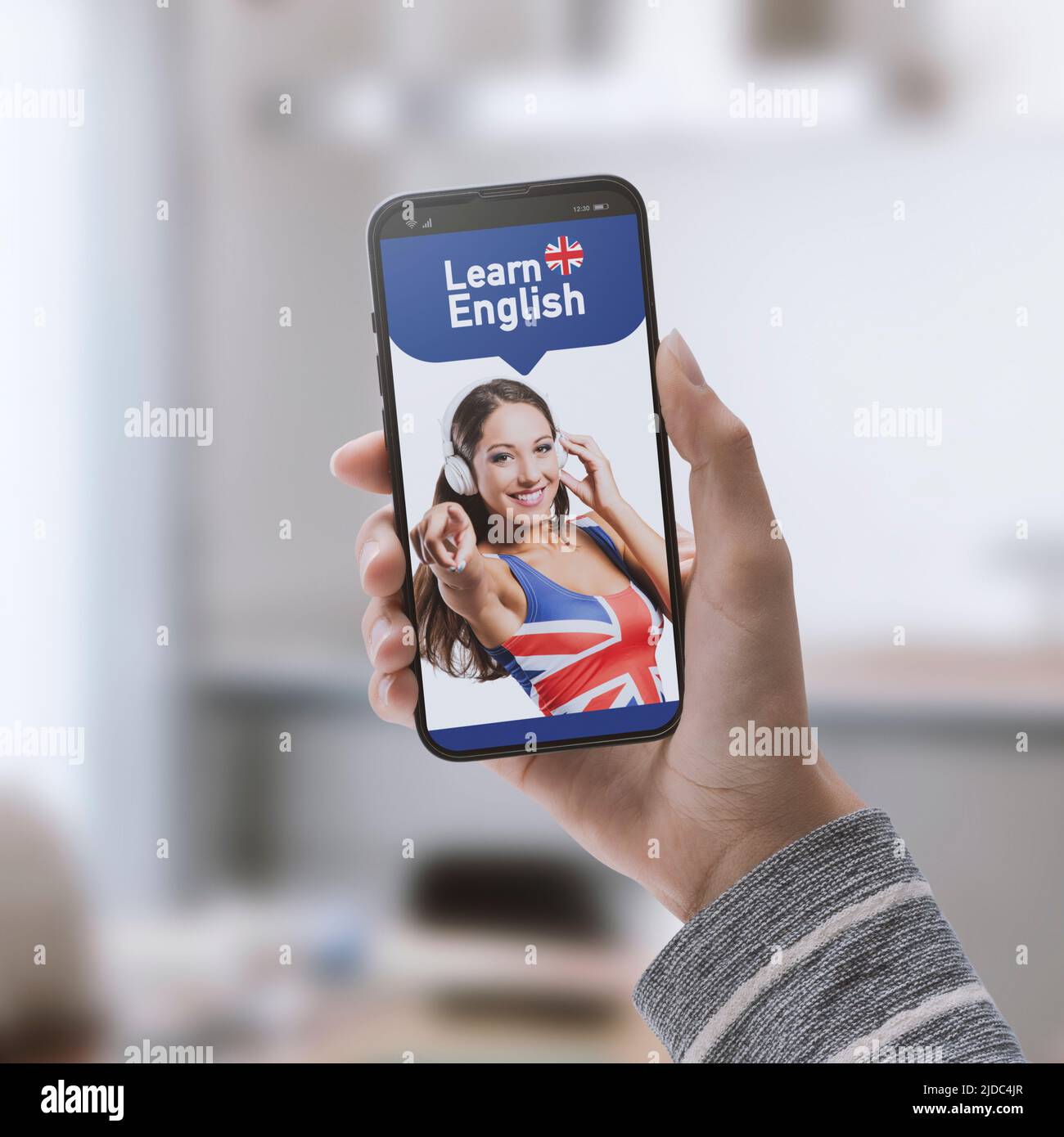 Hand holding a smartphone and English learning app on the phone screen ...