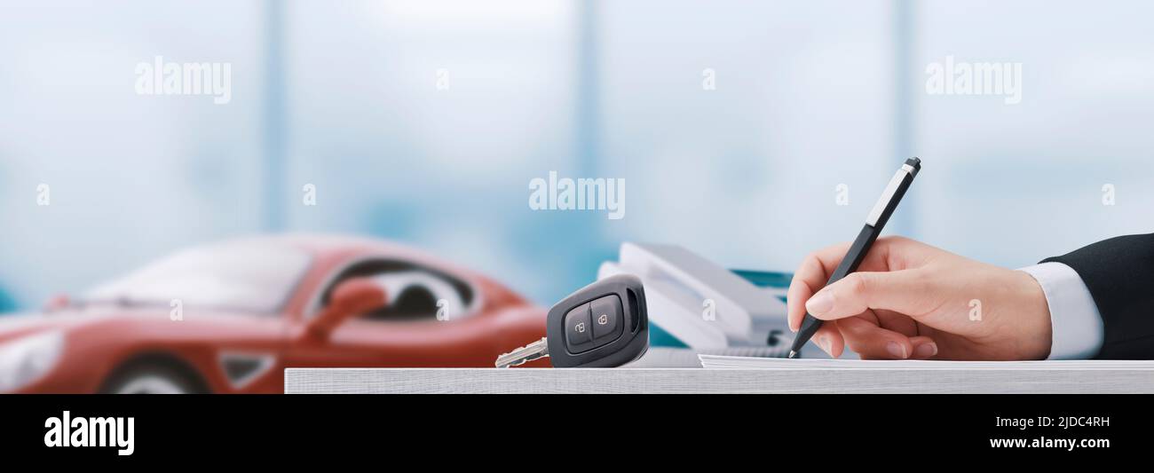 Car salesman writing a contract and luxury car in the background, car ...