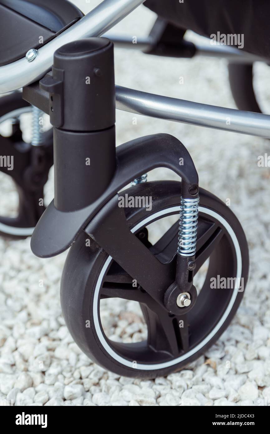 Baby stroller wheel with spring shock absorber close-up, baby stroller ...