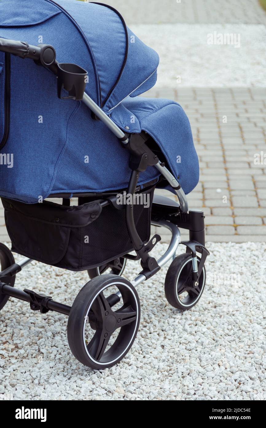 Modern blue baby stroller with hood outdoors rear view Stock Photo - Alamy