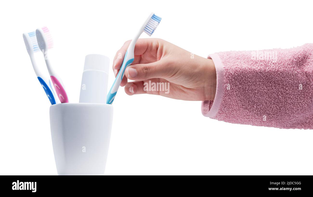 Woman taking her toothbrush iIsolated on white background, she is ...