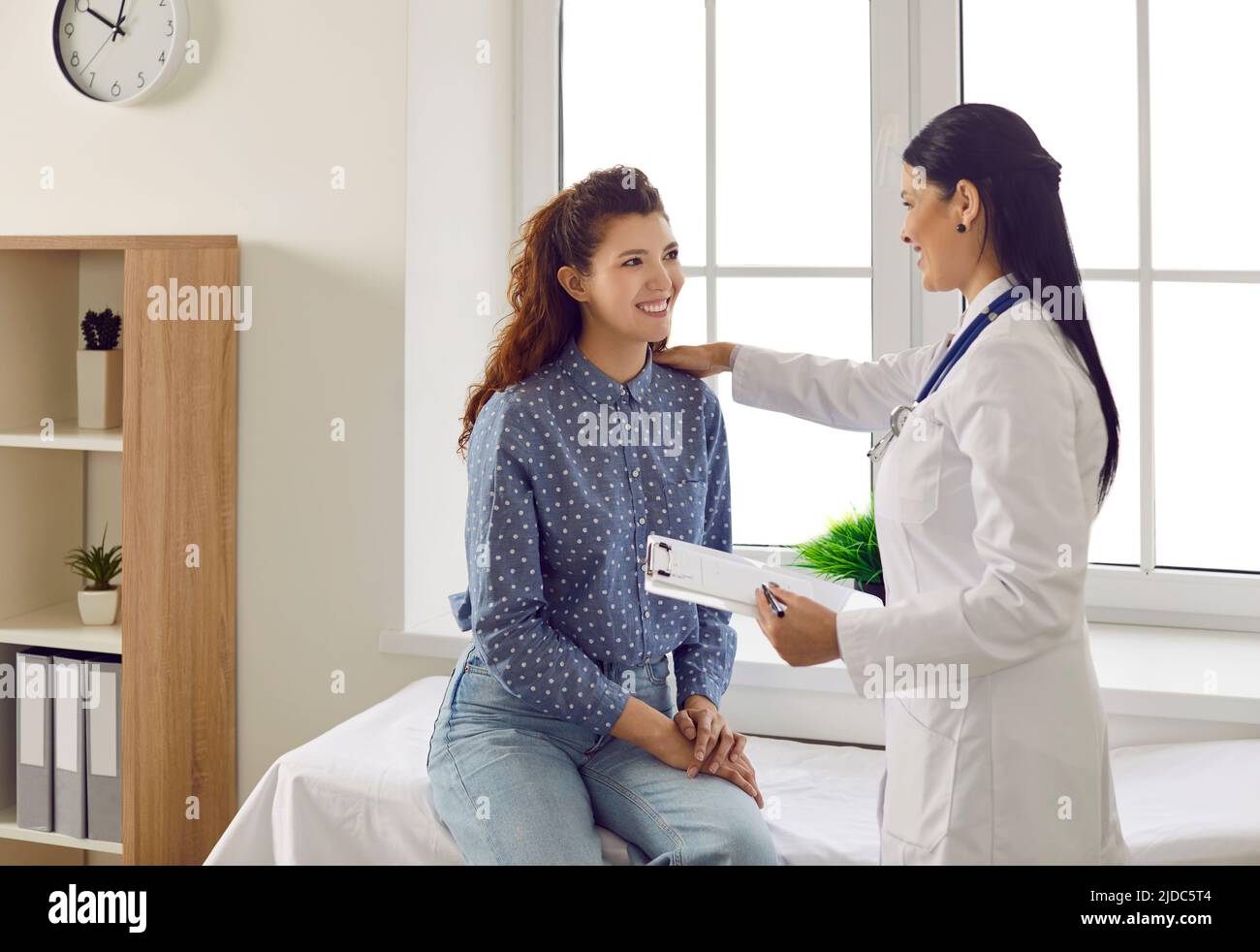 Friendly Smiling Female Doctor Touches Patients Shoulder And Tells Her