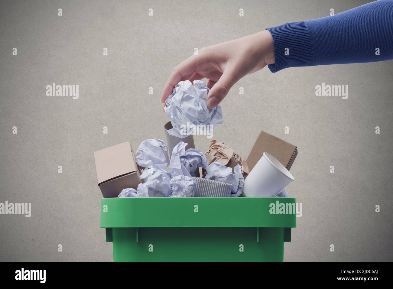 Woman putting paper in the waste bin, separate waste collection and ...