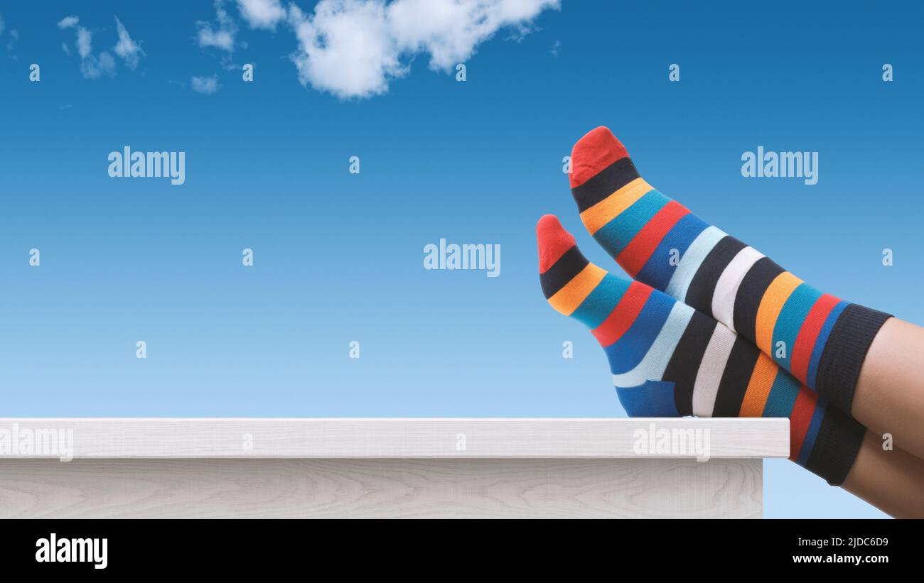 Creative carefree person wearing colorful striped socks and relaxing ...