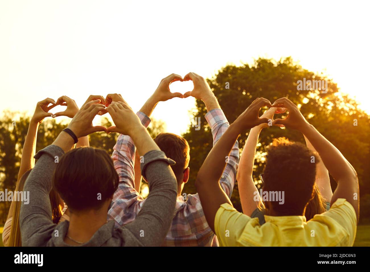 Diverse group of happy people hope for peace, put hands up and do heart ...