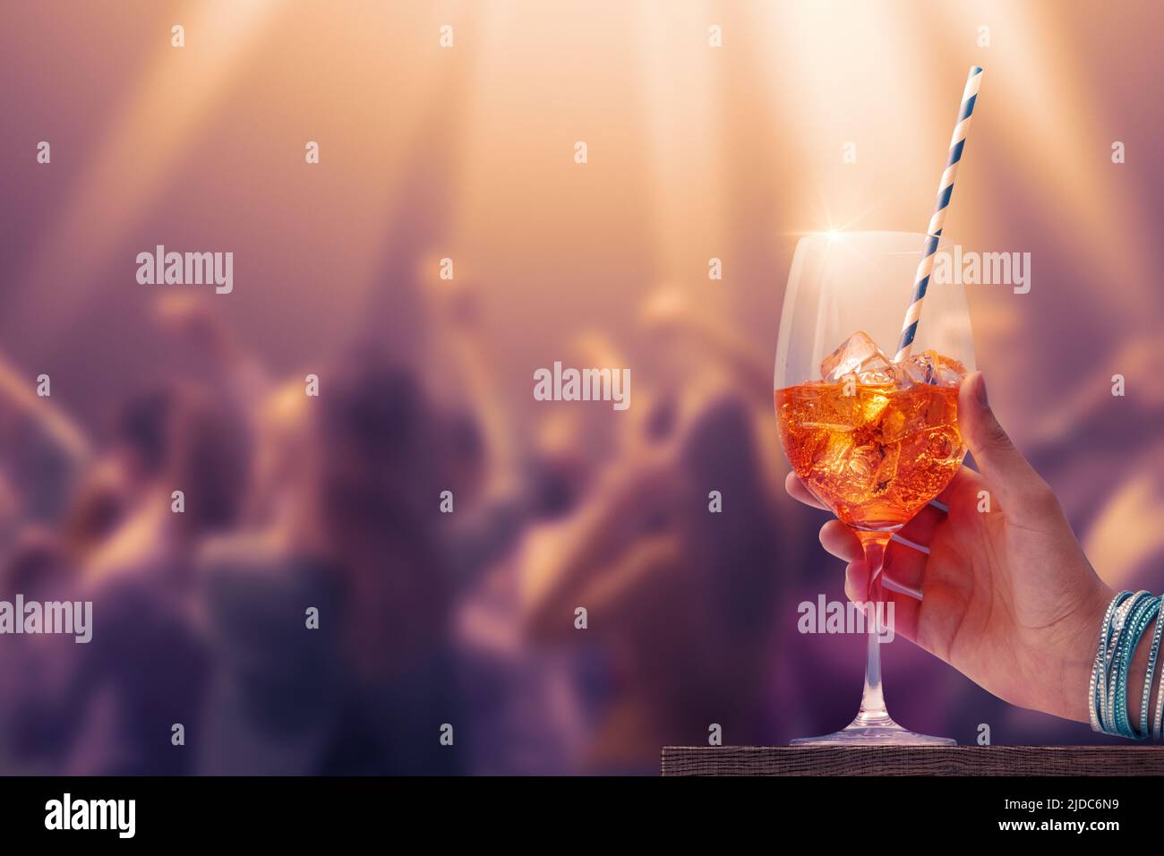 Woman having a delicious cocktail at the nightclub and crowd of people ...