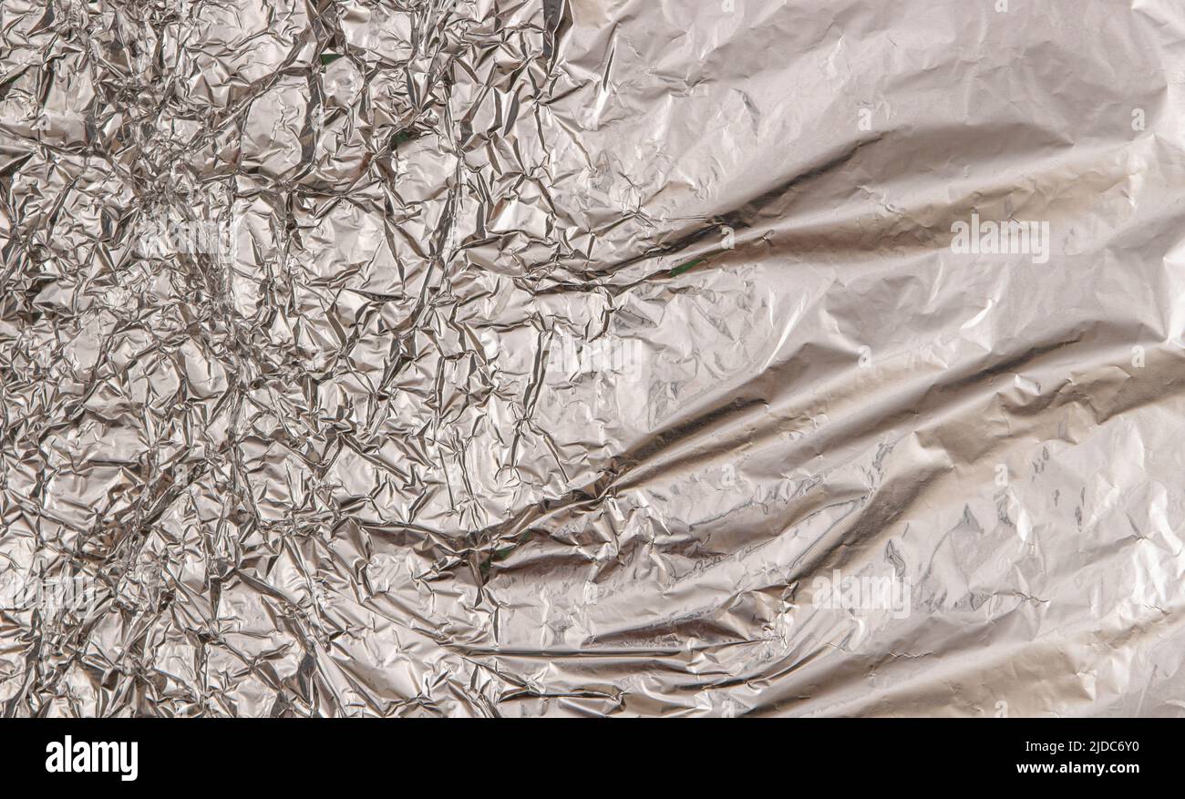 Silver shiny crumpled foil texture background. Top view Stock Photo - Alamy